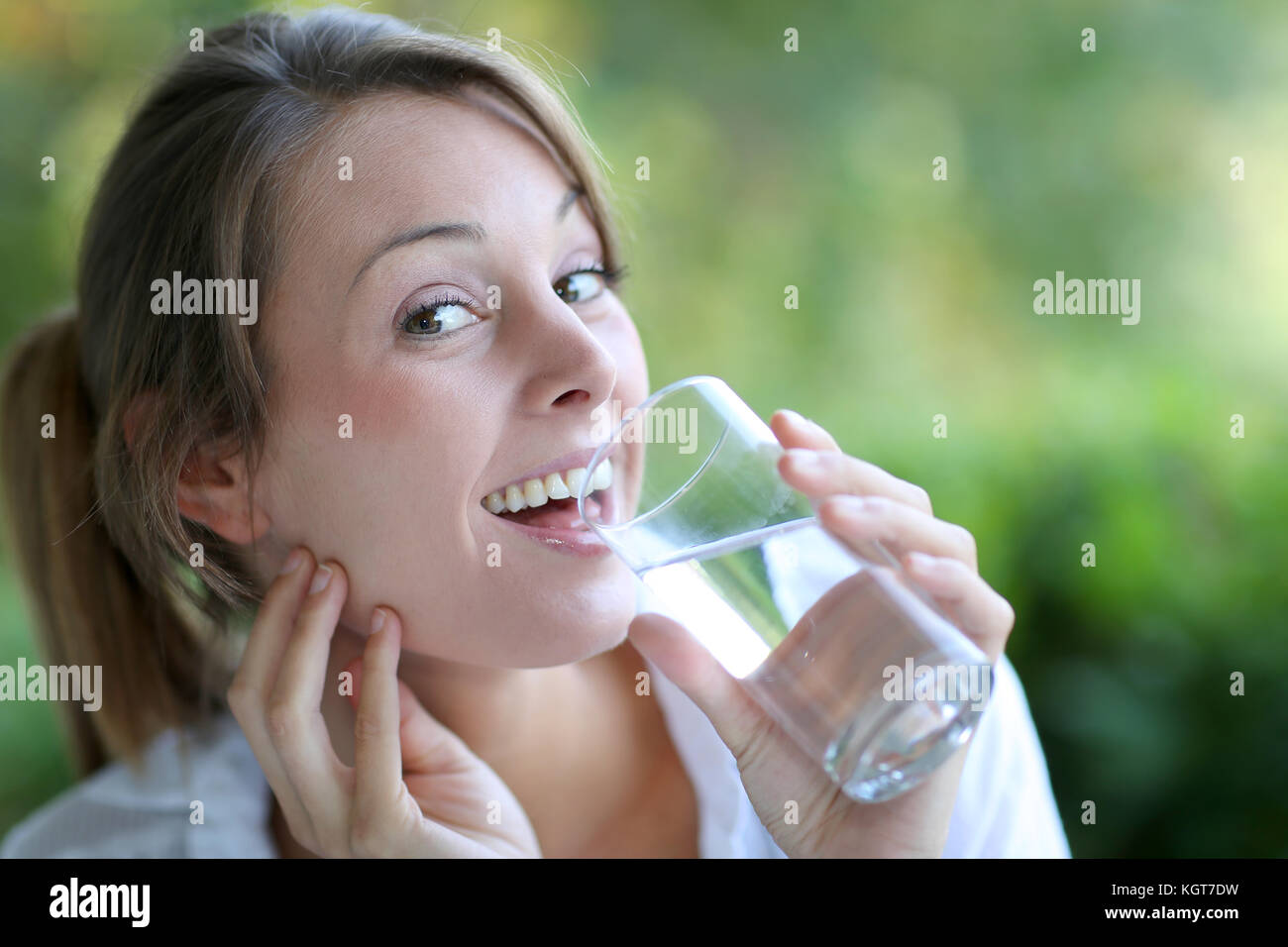 Smiling woman drinking fresh water from glass Stock Photo - Alamy
