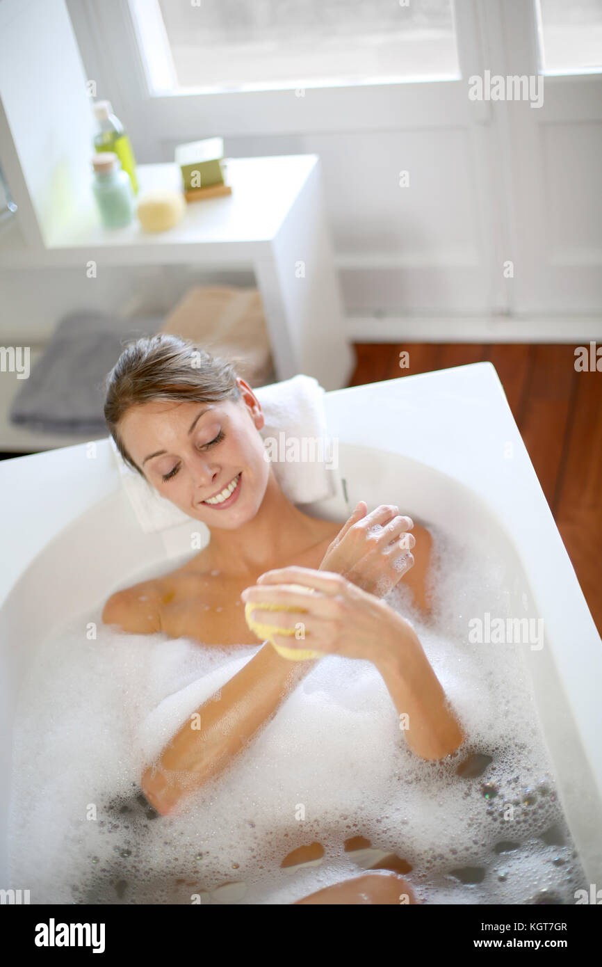 Beautiful woman using bath sponge Stock Photo - Alamy