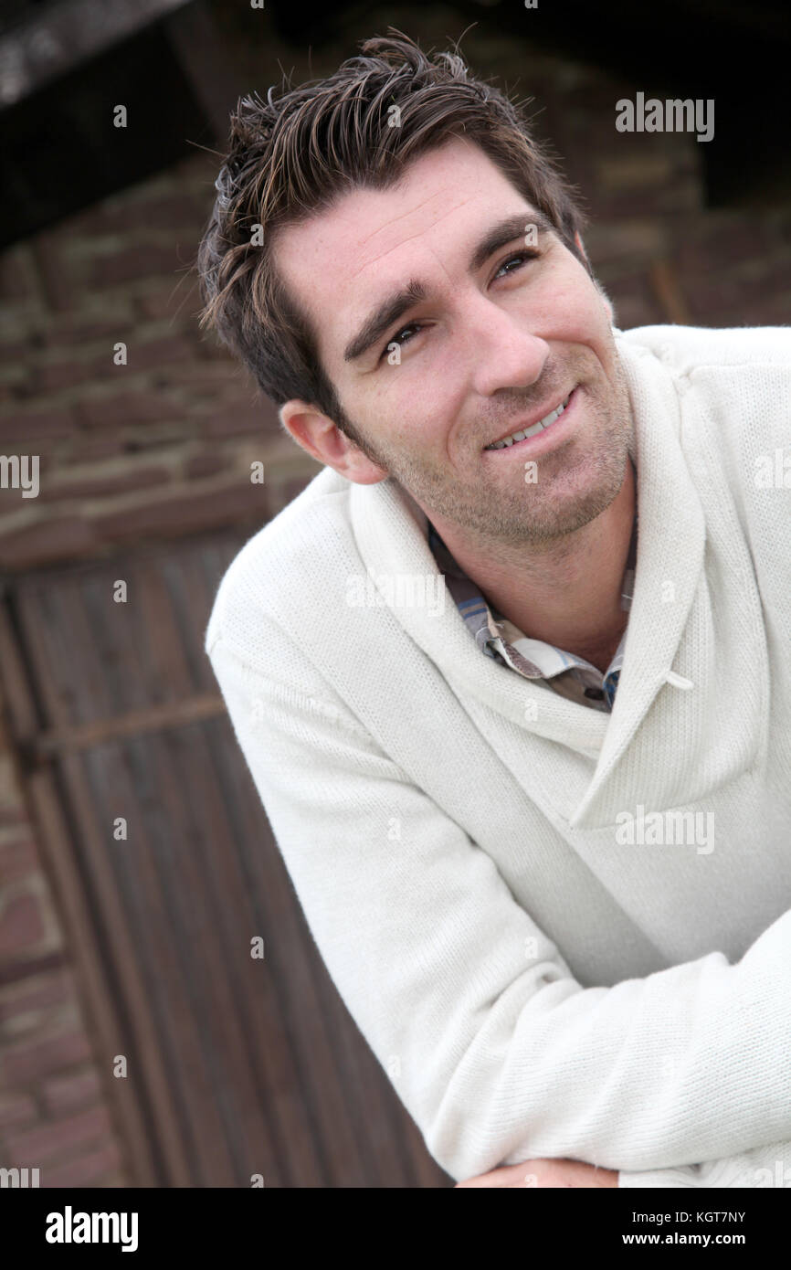 Smiling man standing in front of countryhouse Stock Photo - Alamy