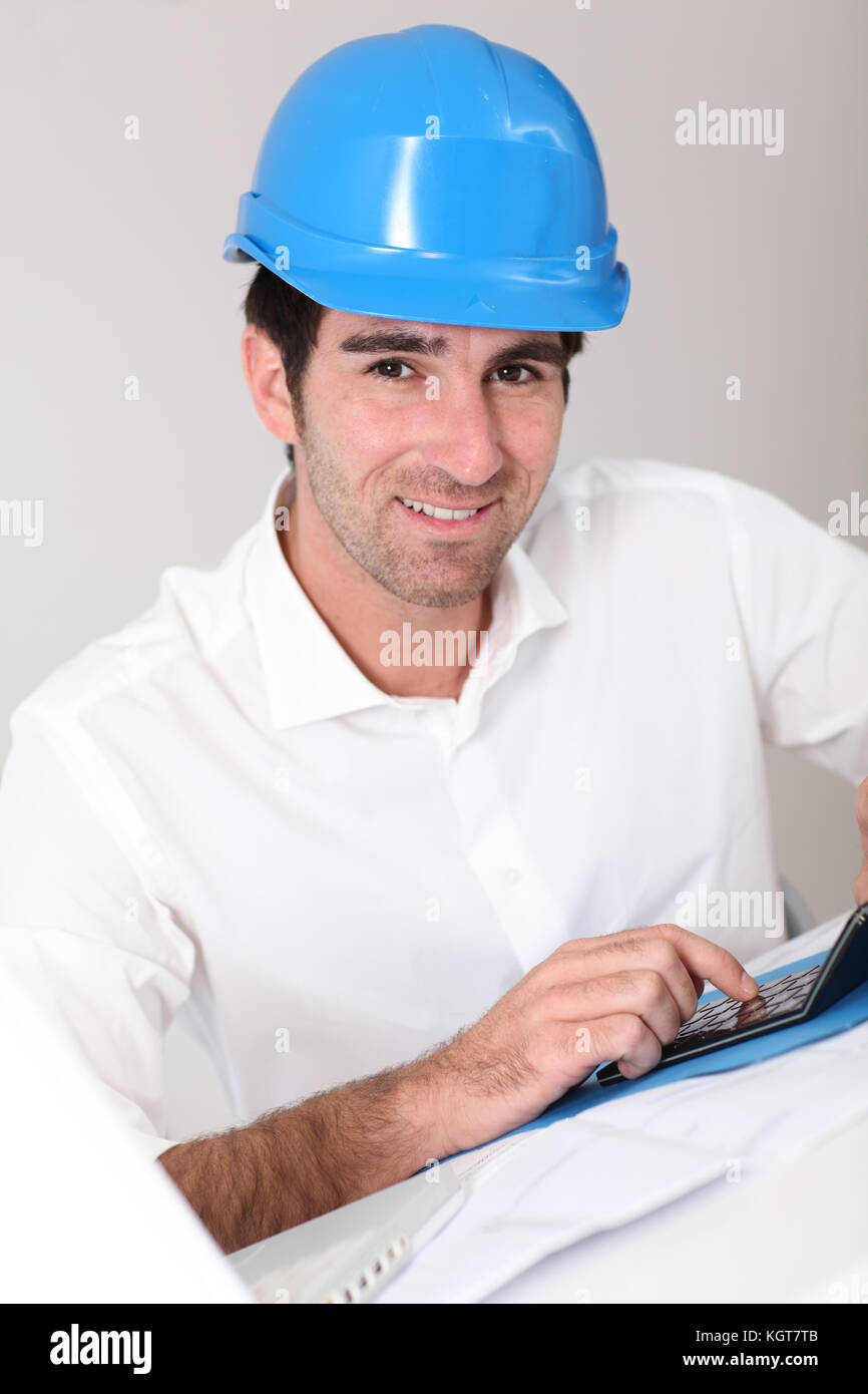 Site manager in office with security helmet Stock Photo - Alamy