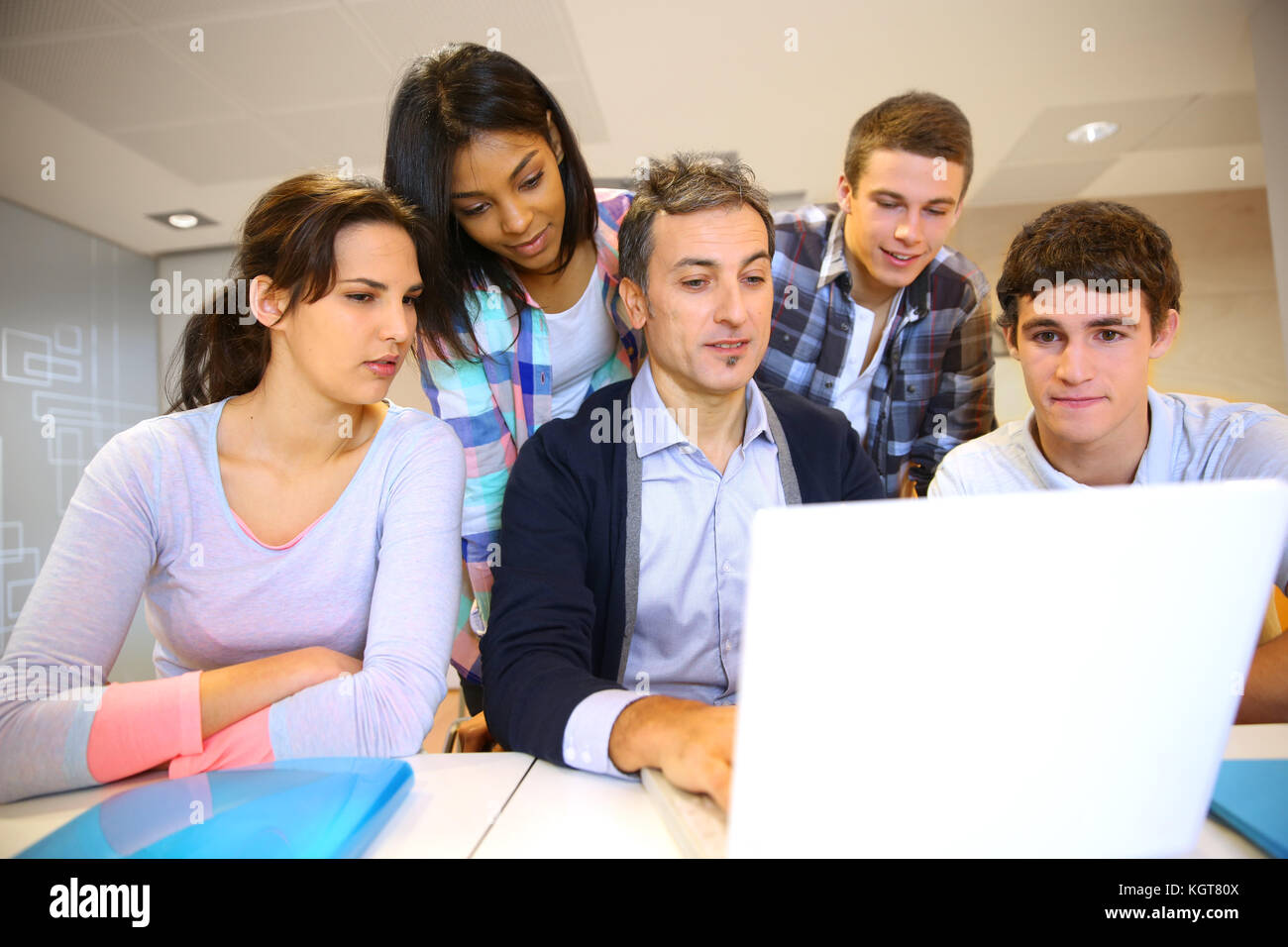 Teacher with students in class working on laptop Stock Photo - Alamy
