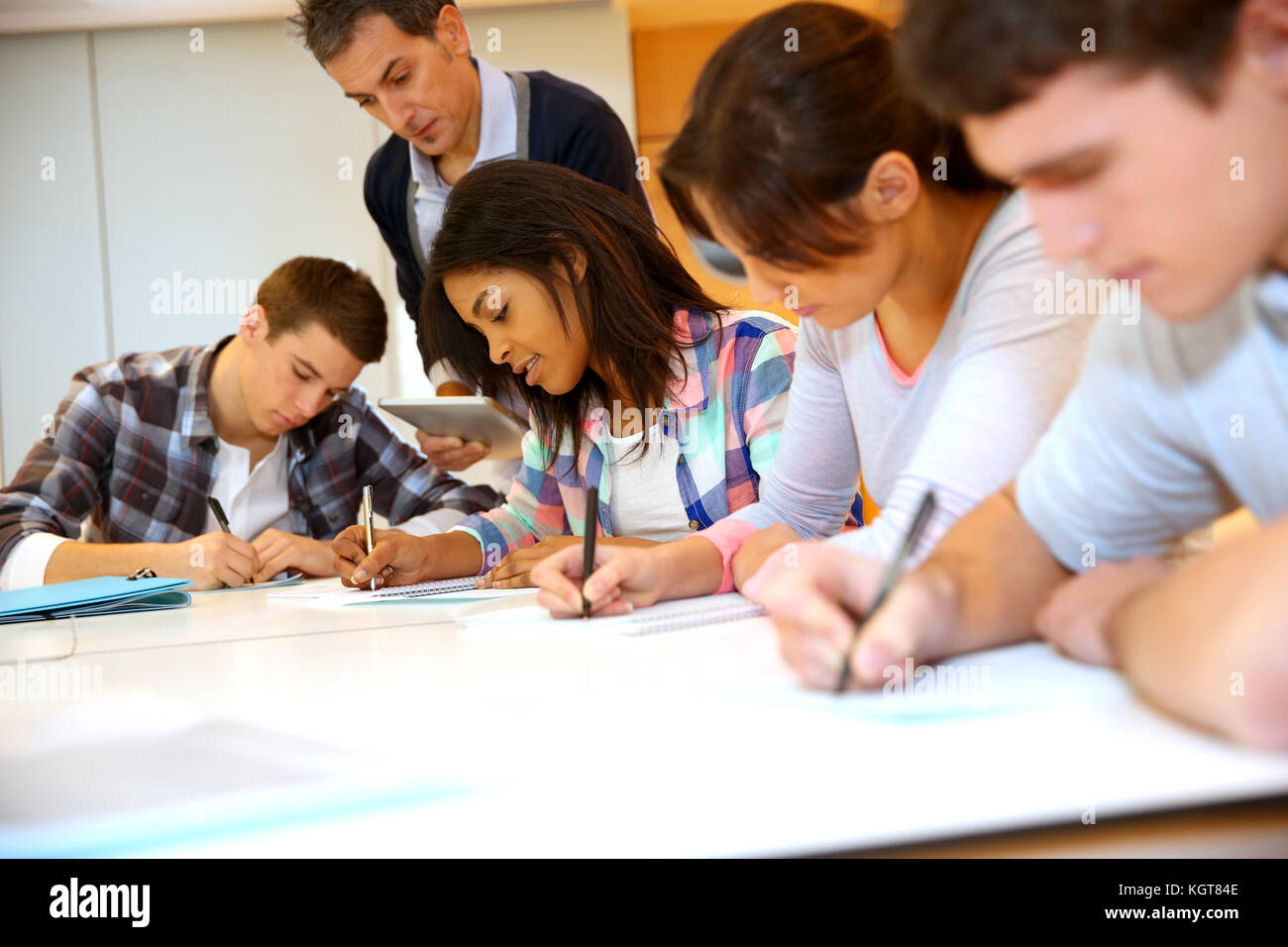 Group of teenagers in class writing an exam Stock Photo - Alamy