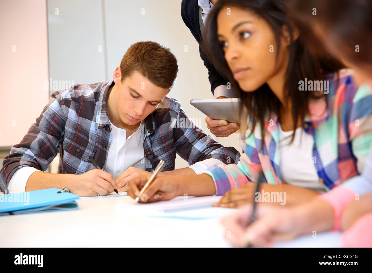 Group of teenagers in class writing an exam Stock Photo - Alamy