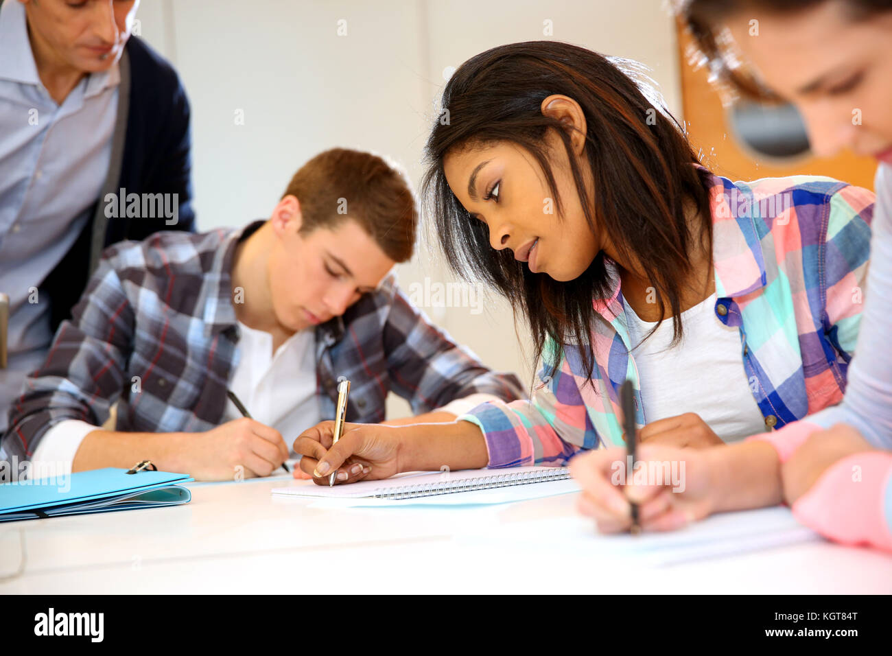 Group of teenagers in class writing an exam Stock Photo - Alamy
