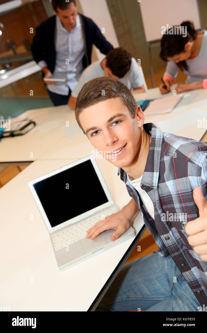 Student with laptop showing thumb up Stock Photo - Alamy