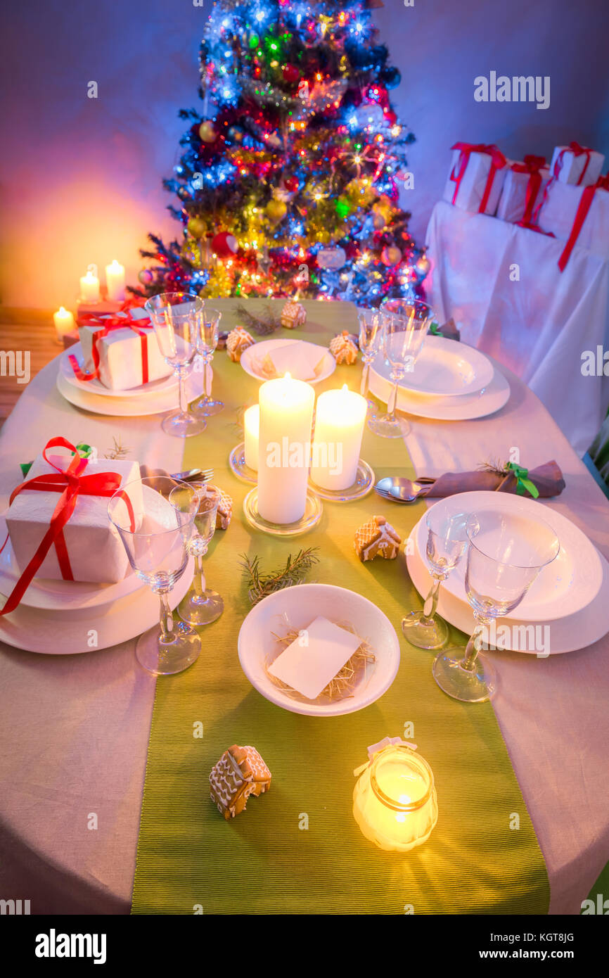Family Christmas table setting with present and tree in evening Stock ...