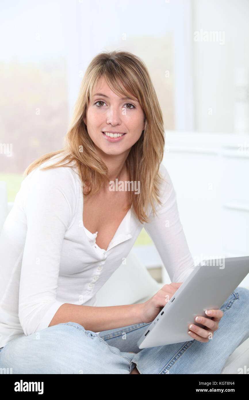 Blond woman using electronic tablet at home Stock Photo - Alamy