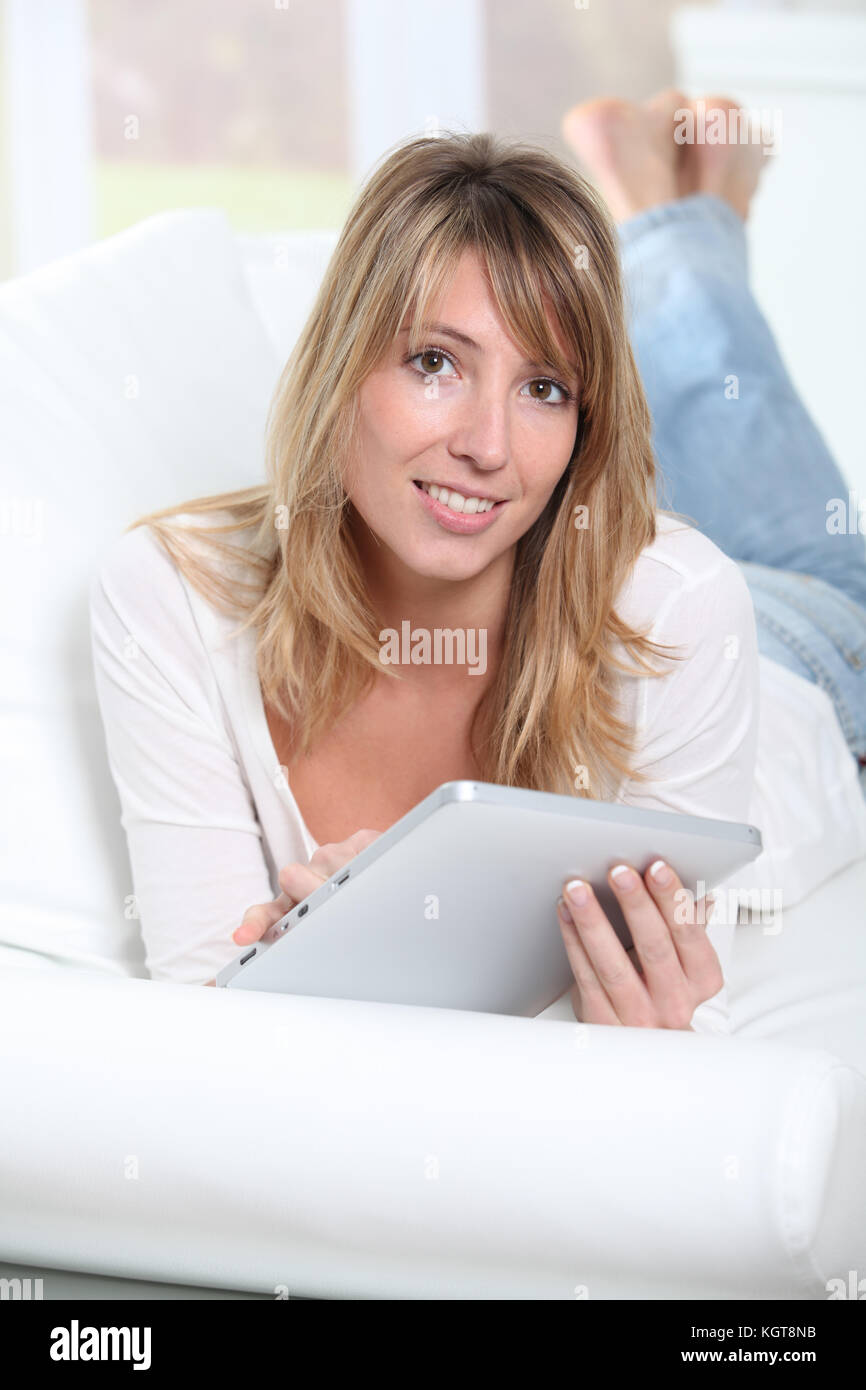 Blond woman using electronic tablet at home Stock Photo - Alamy