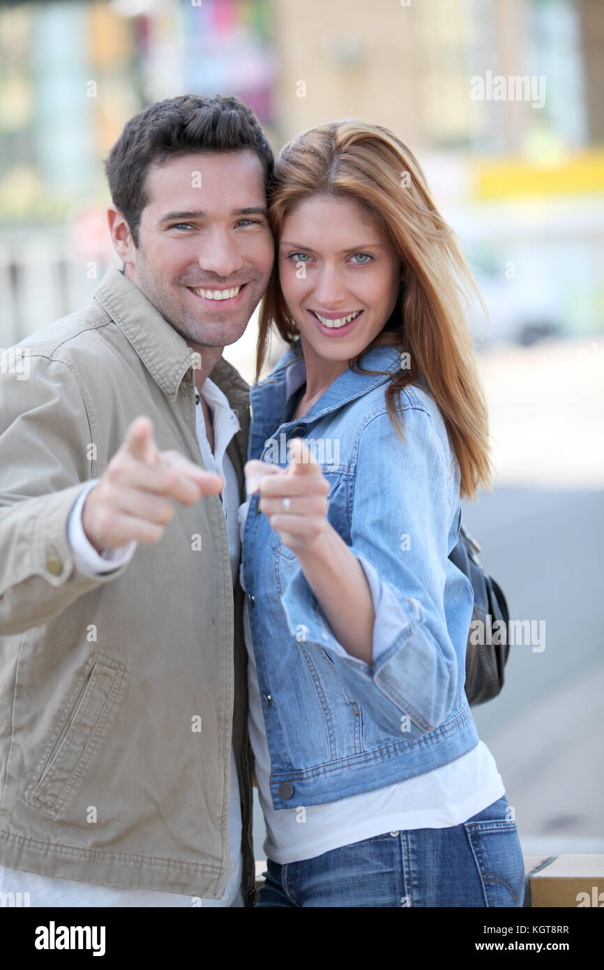 Happy couple with thumbs up in town Stock Photo - Alamy