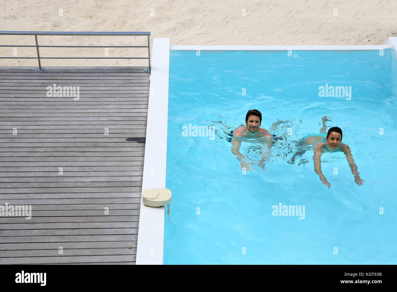 Upper view of couple swimming in infinity pool Stock Photo - Alamy