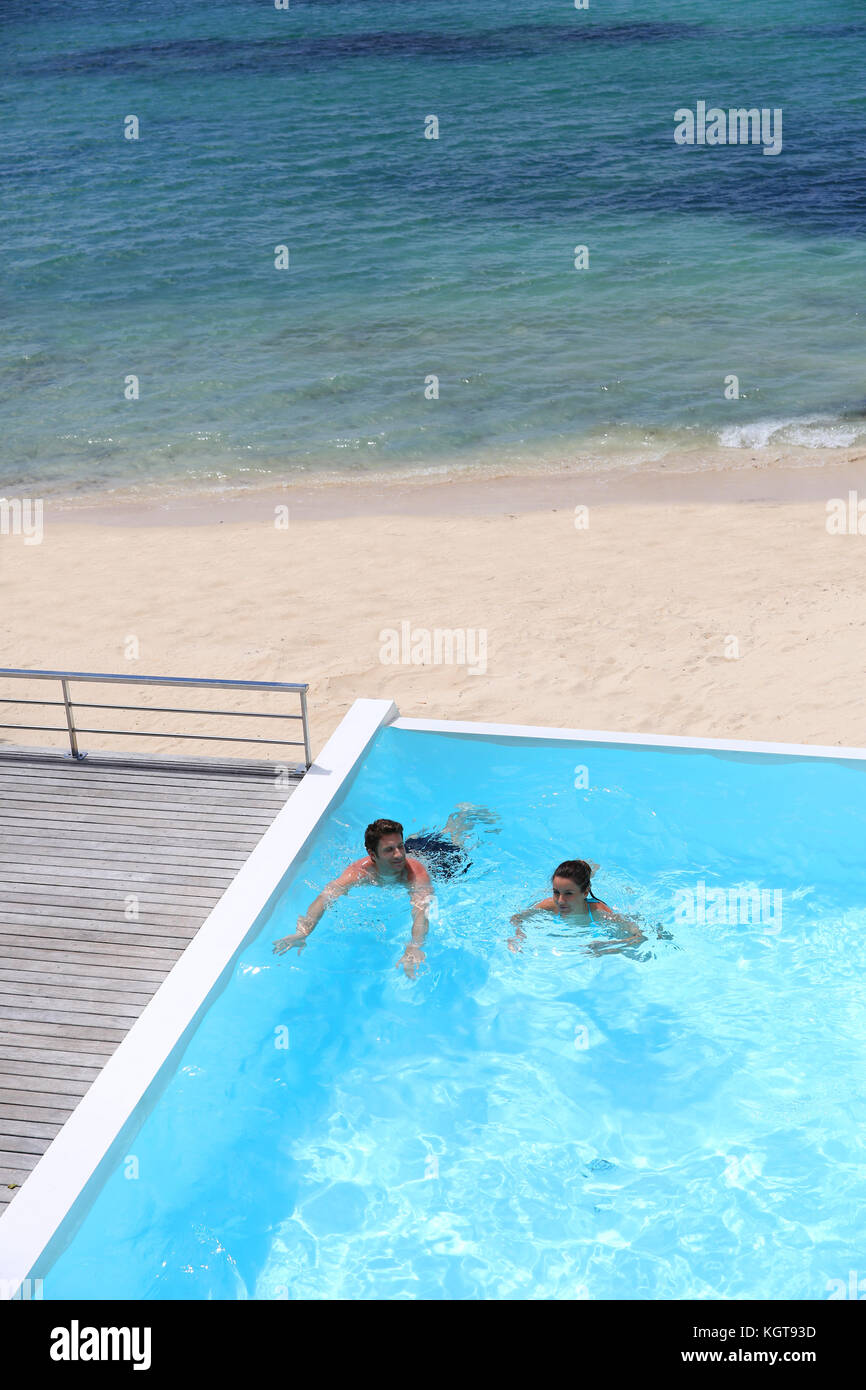 Upper view of couple swimming in infinity pool Stock Photo - Alamy