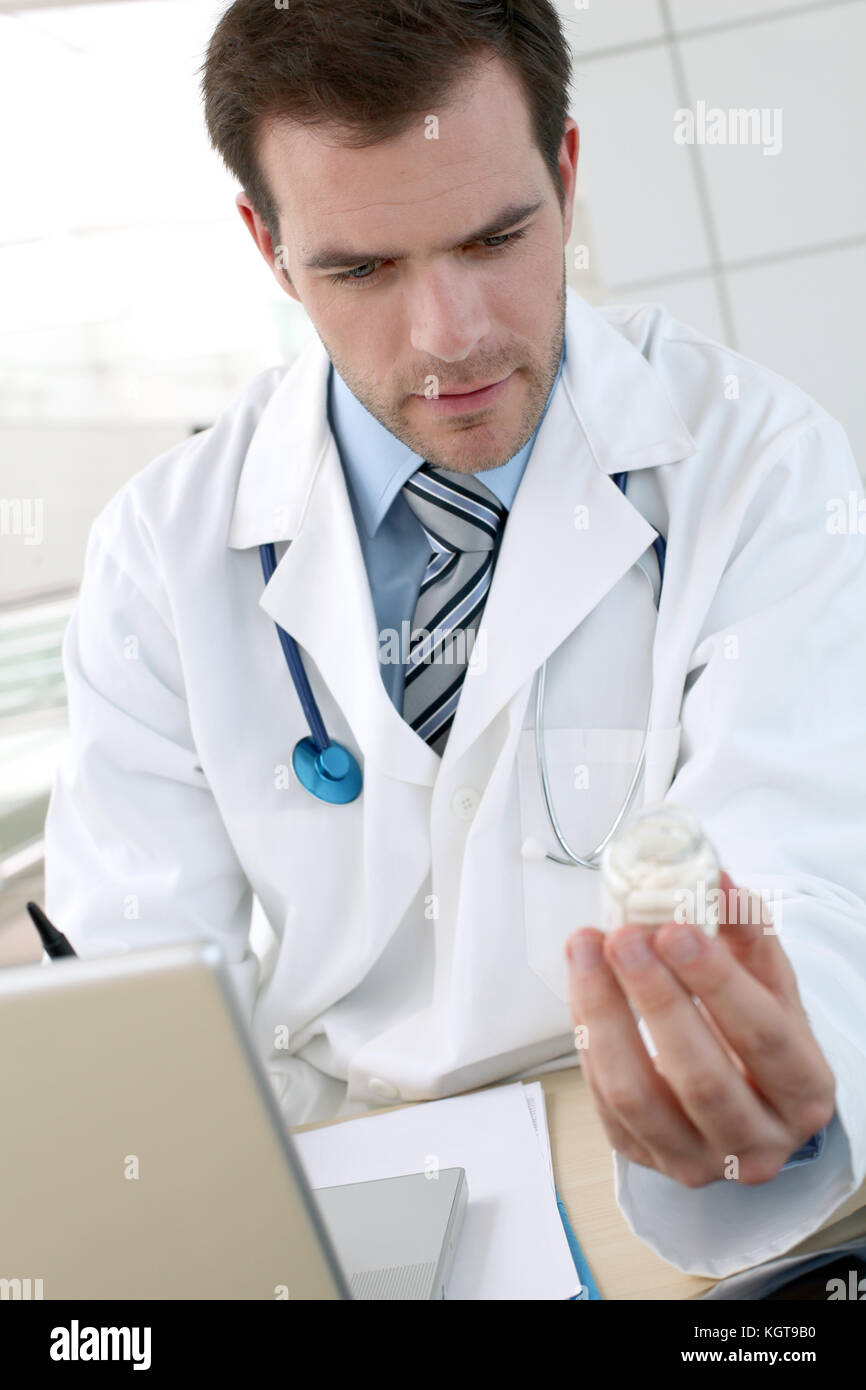 Doctor with laptop computer checking medicine composition Stock Photo ...