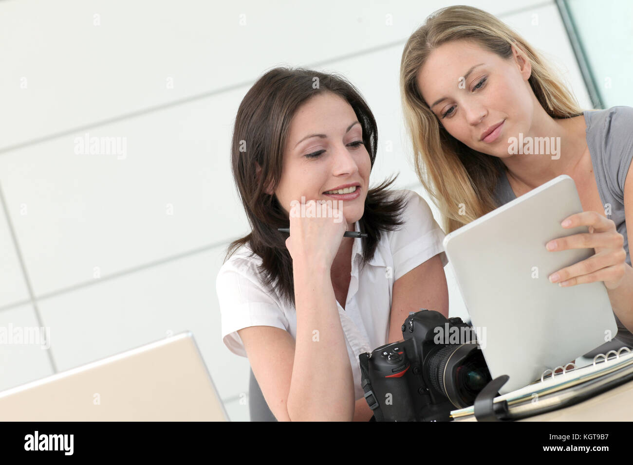 Women photographers working in office with tablet Stock Photo - Alamy