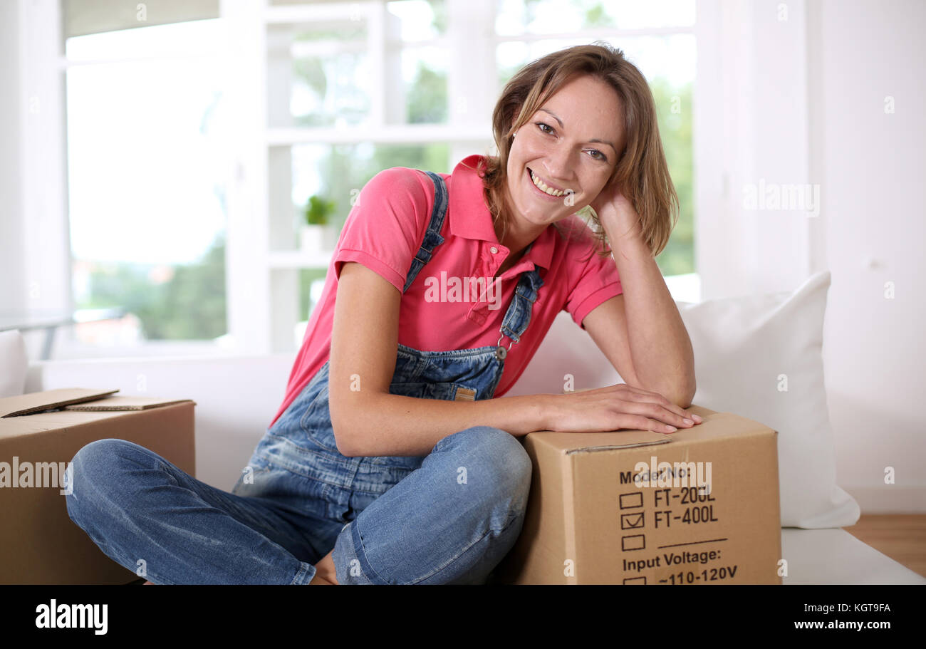 Portrait of cheerful woman moving in new house Stock Photo - Alamy