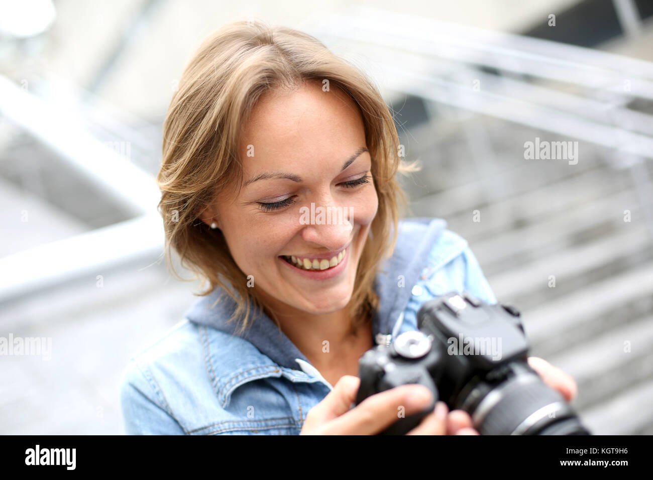 Woman using photo camera in town Stock Photo - Alamy