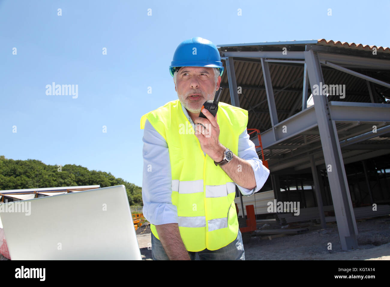 Site manager using walkie-talkie Stock Photo - Alamy