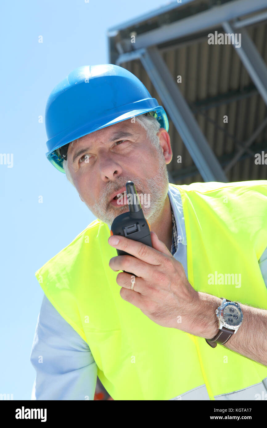 Site manager using walkie-talkie Stock Photo - Alamy