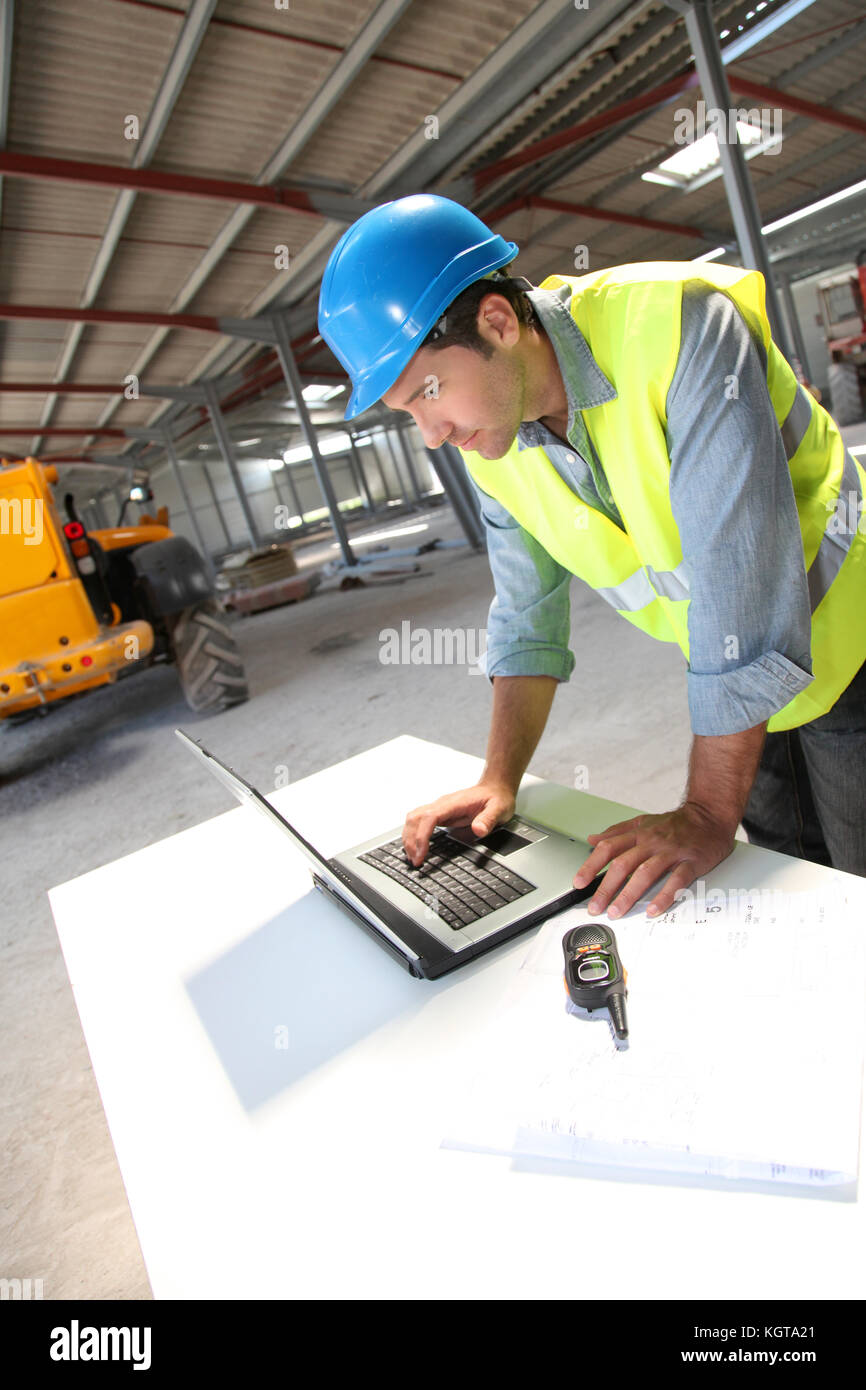 Engineer using laptop computer on construction site Stock Photo - Alamy