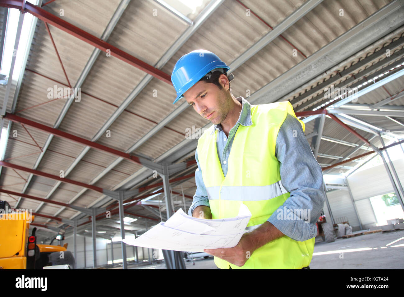 Engineer checking plan in building under construction Stock Photo - Alamy