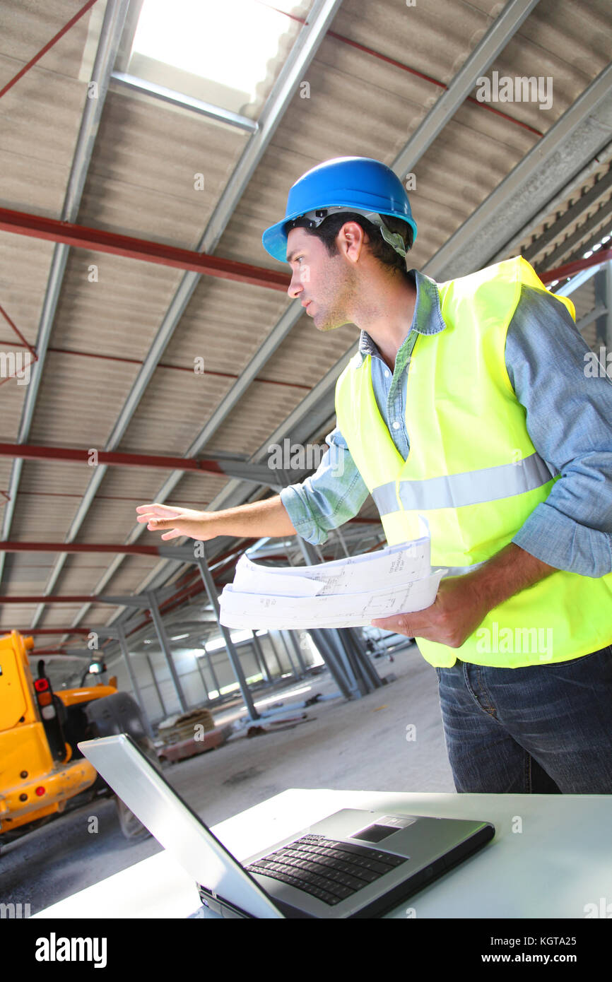 Engineer checking plan in building under construction Stock Photo - Alamy