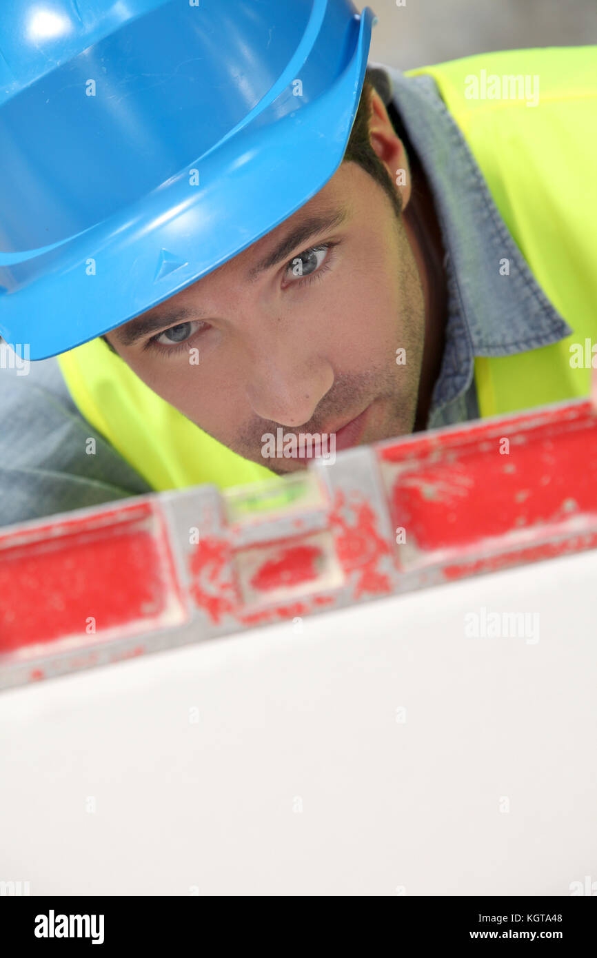 Worker using level on building site Stock Photo - Alamy