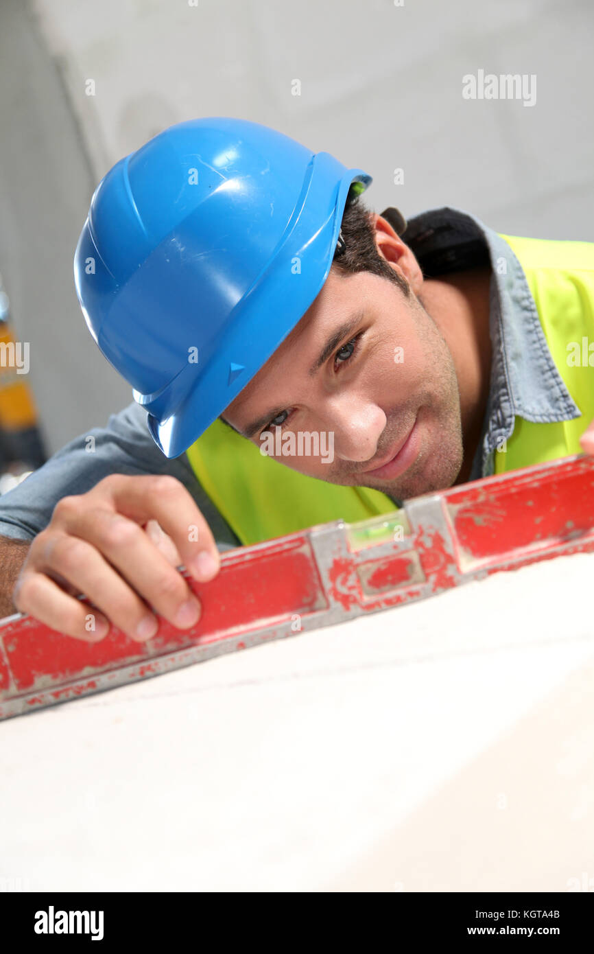 Worker using level on building site Stock Photo - Alamy