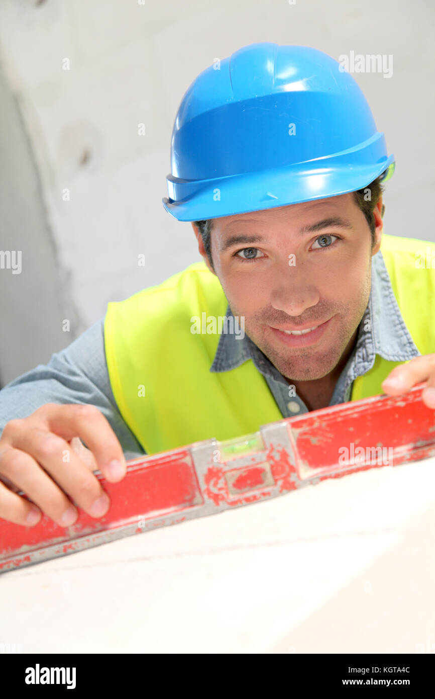 Worker using level on building site Stock Photo - Alamy