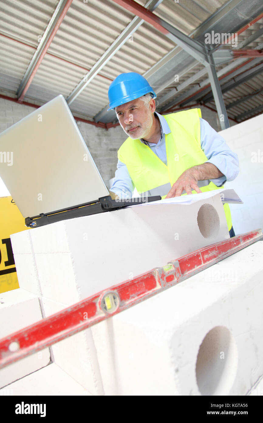 Architect using laptop computer on construction site Stock Photo - Alamy