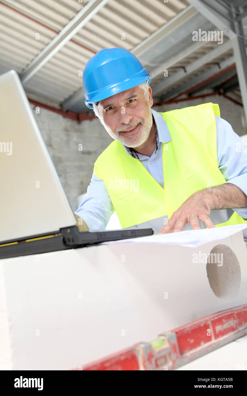 Architect using laptop computer on construction site Stock Photo - Alamy