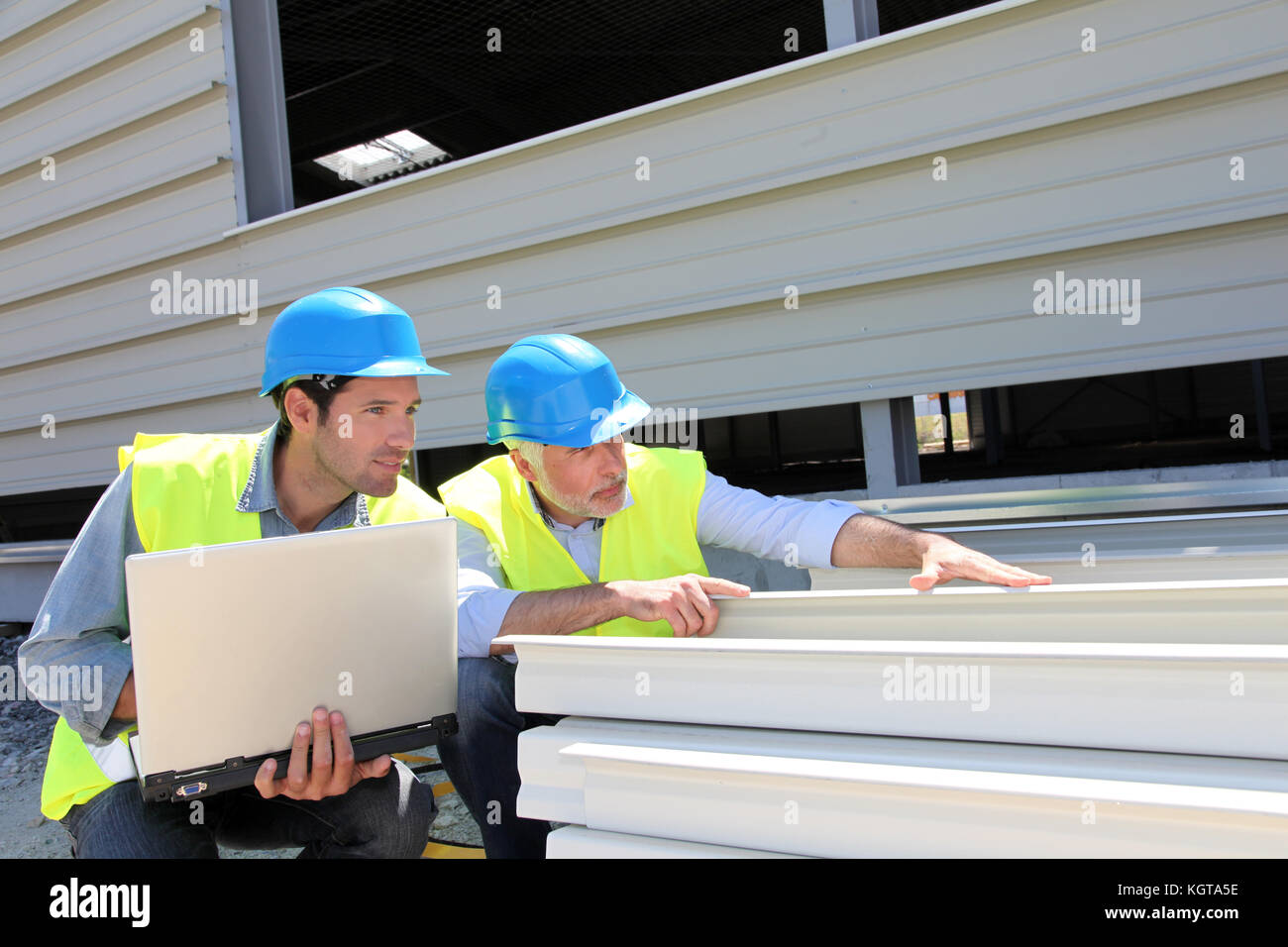 Construction workers checking building material Stock Photo - Alamy