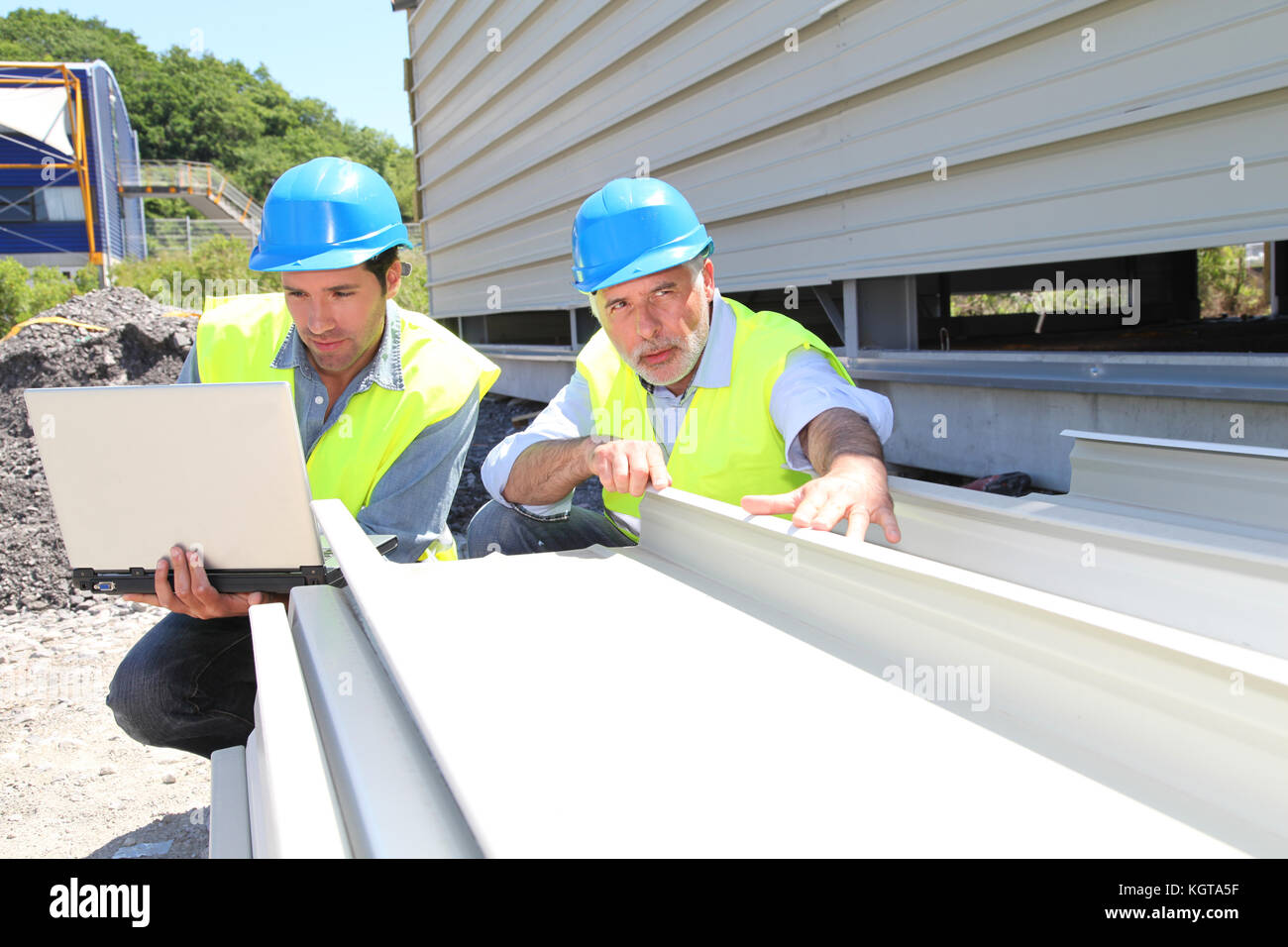 Construction workers checking building material Stock Photo - Alamy