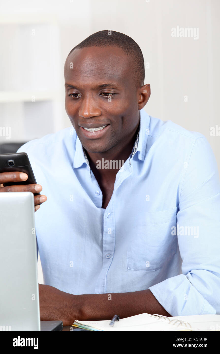 Salesman in office using mobile phone Stock Photo - Alamy
