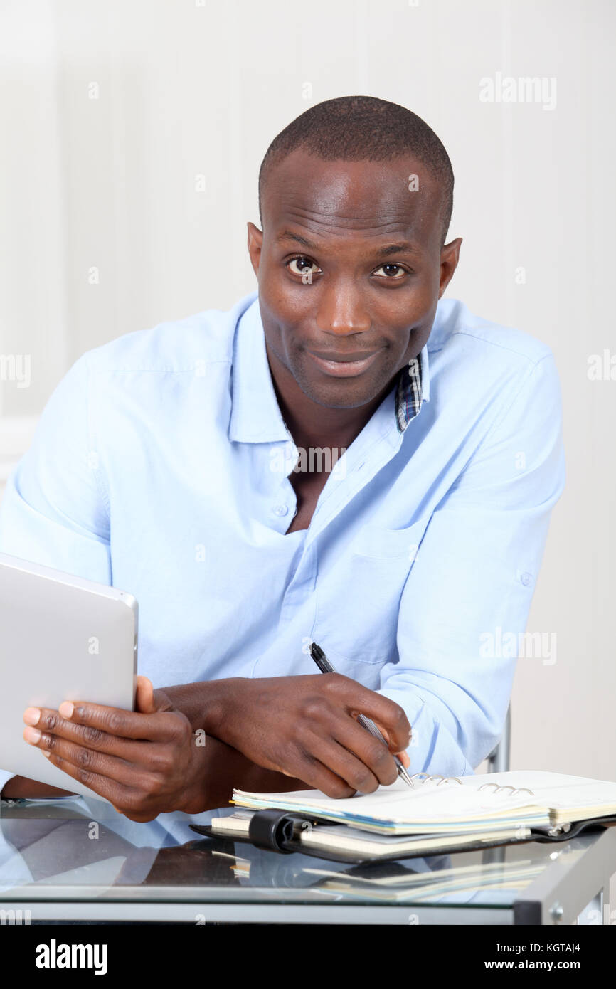 Office worker using electronic tablet at work Stock Photo - Alamy