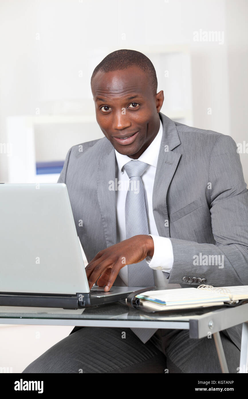 Businessman sitting at his desk in office Stock Photo - Alamy