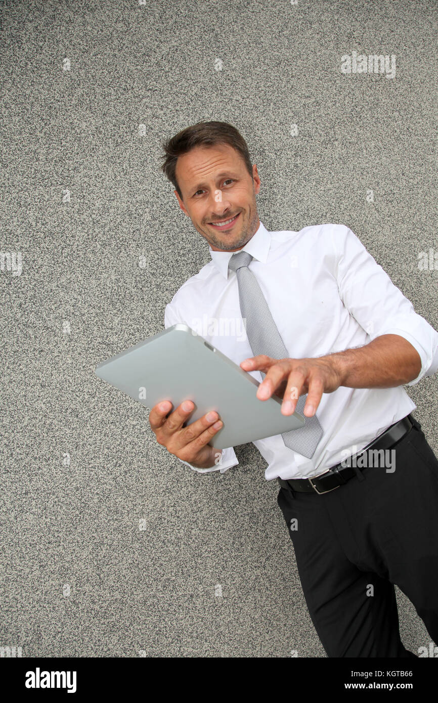 Smiling salesman using electronic tablet Stock Photo - Alamy Smiling salesman using electronic tablet Stock Photo - Alamy