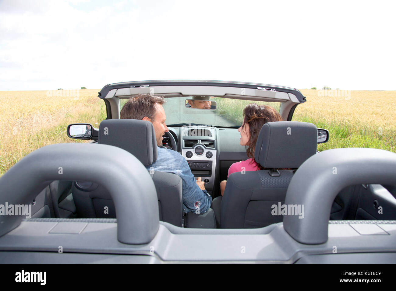 Couple riding convertible car Stock Photo - Alamy