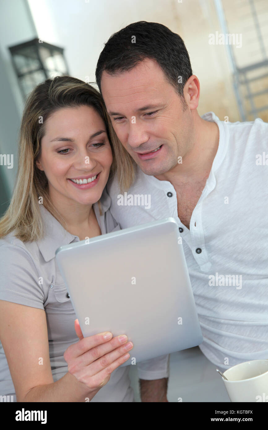Couple at home using electronic tablet Stock Photo - Alamy