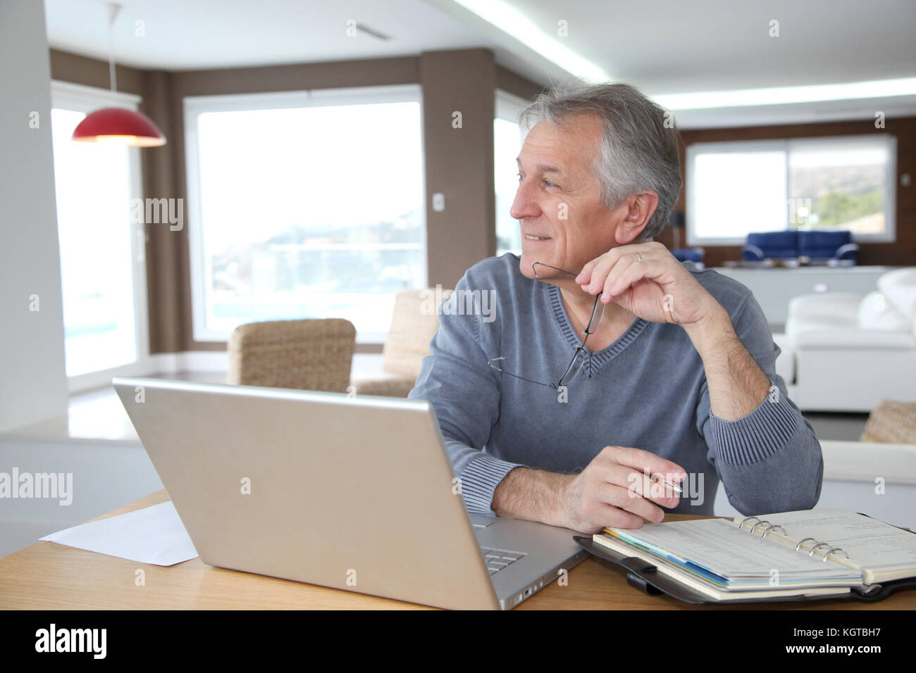 Senior man at home in front of laptop computer Stock Photo - Alamy