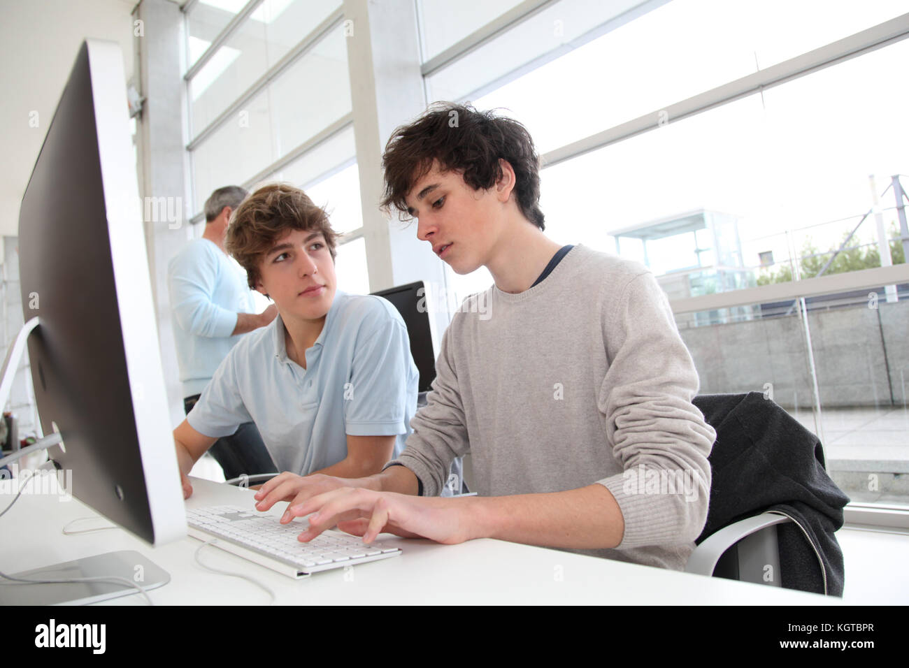 Teenagers in classroom working on desktop computer Stock Photo - Alamy
