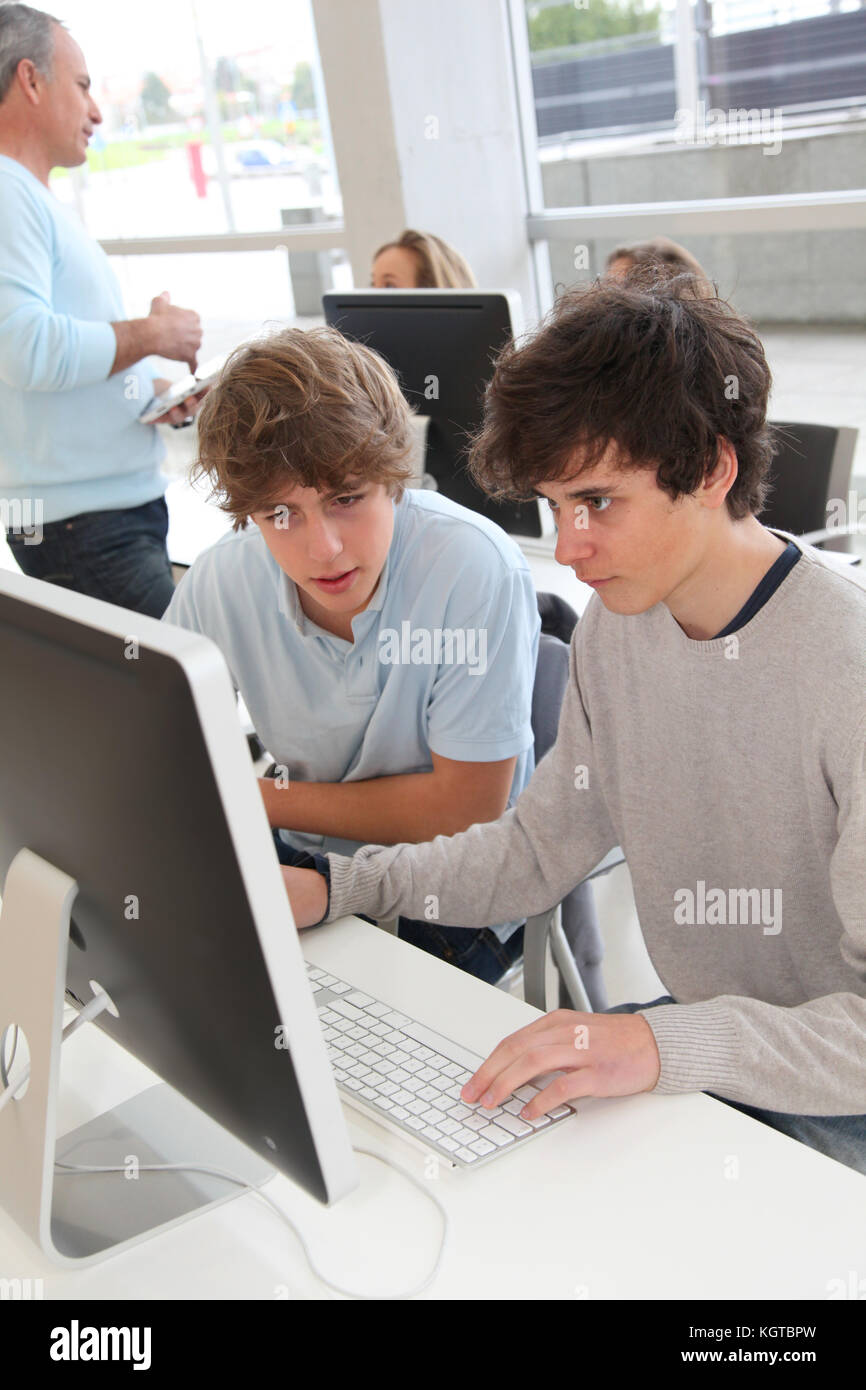 Teenagers in classroom working on desktop computer Stock Photo - Alamy