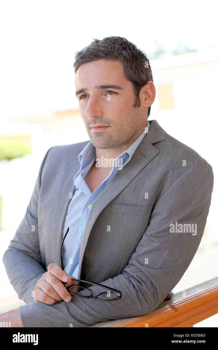 Portrait of confident salesman leaning on balustrade Stock Photo - Alamy