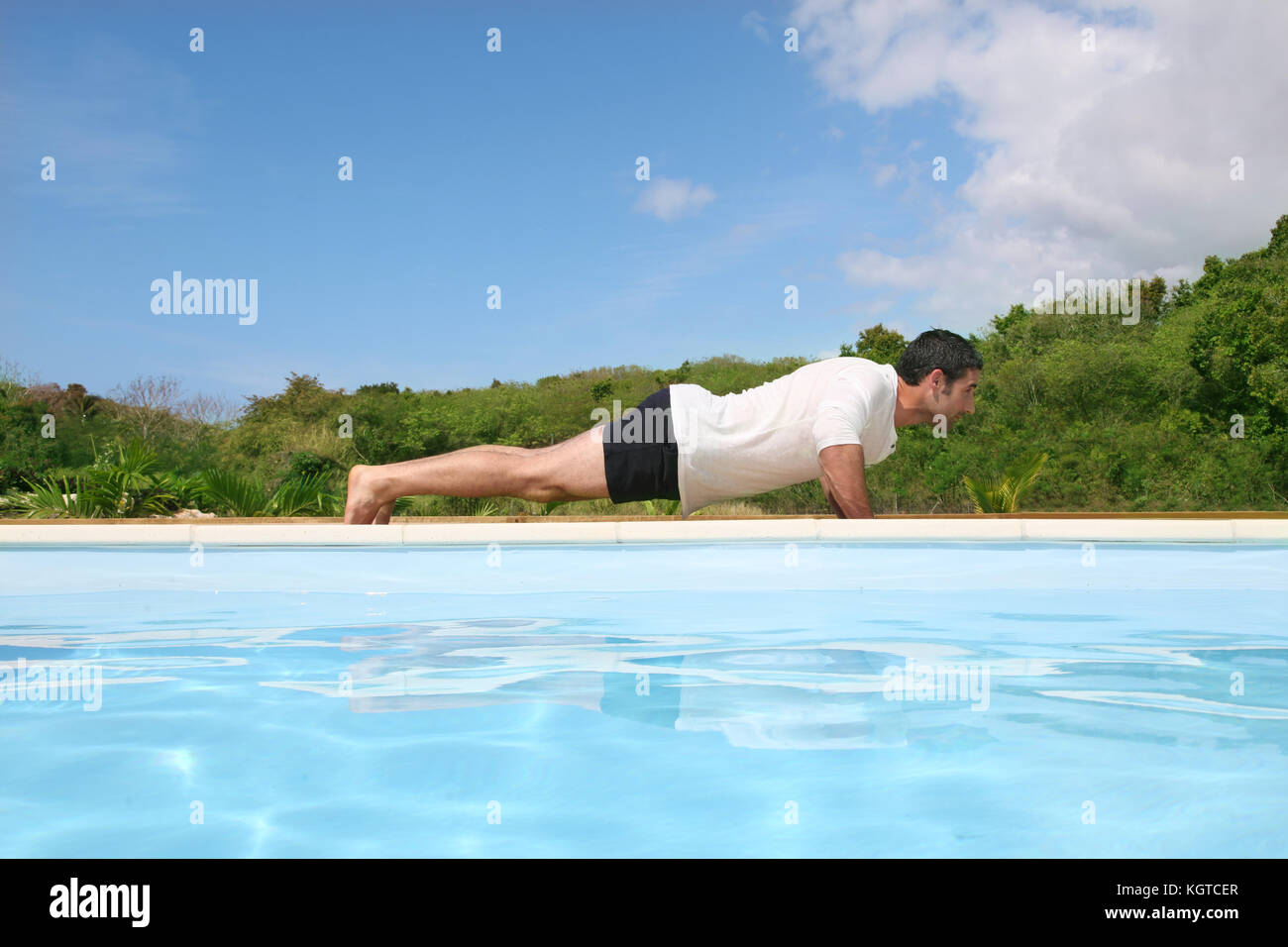 Man doing exercises by the pool Stock Photo - Alamy
