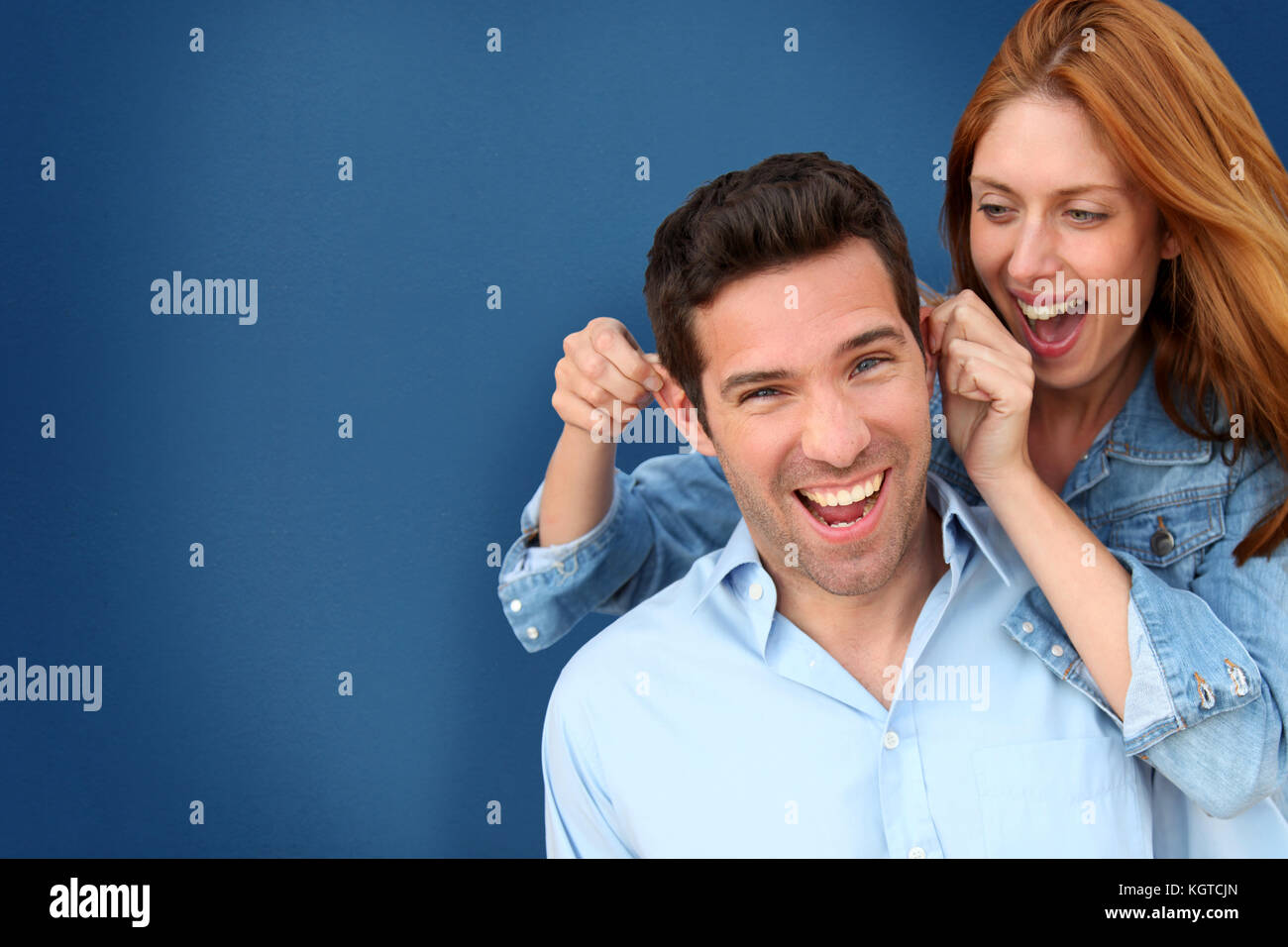 Woman pulling on her boyfriend's ears Stock Photo - Alamy