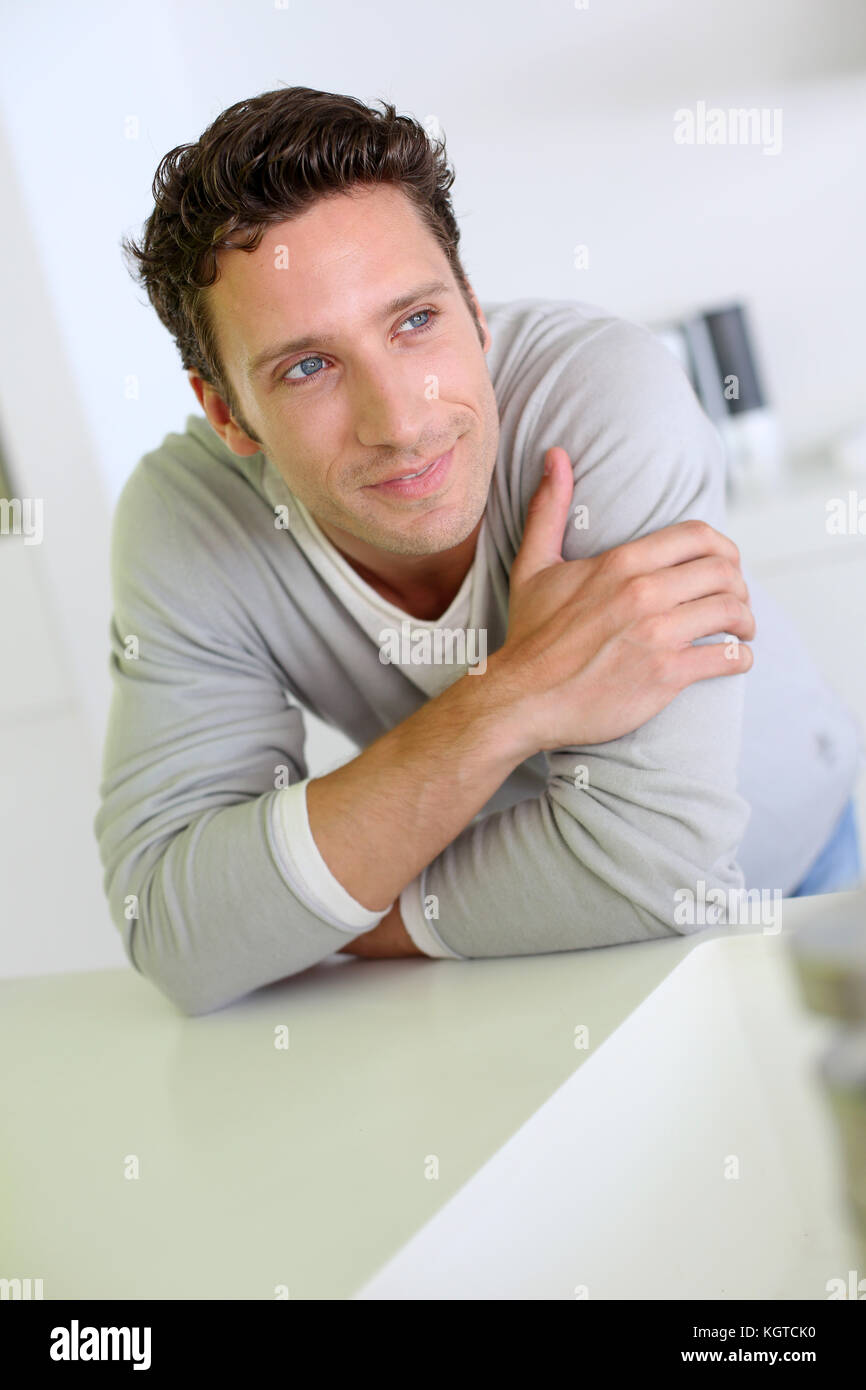 Portrait of handsome man leaning on kitchen counter Stock Photo - Alamy