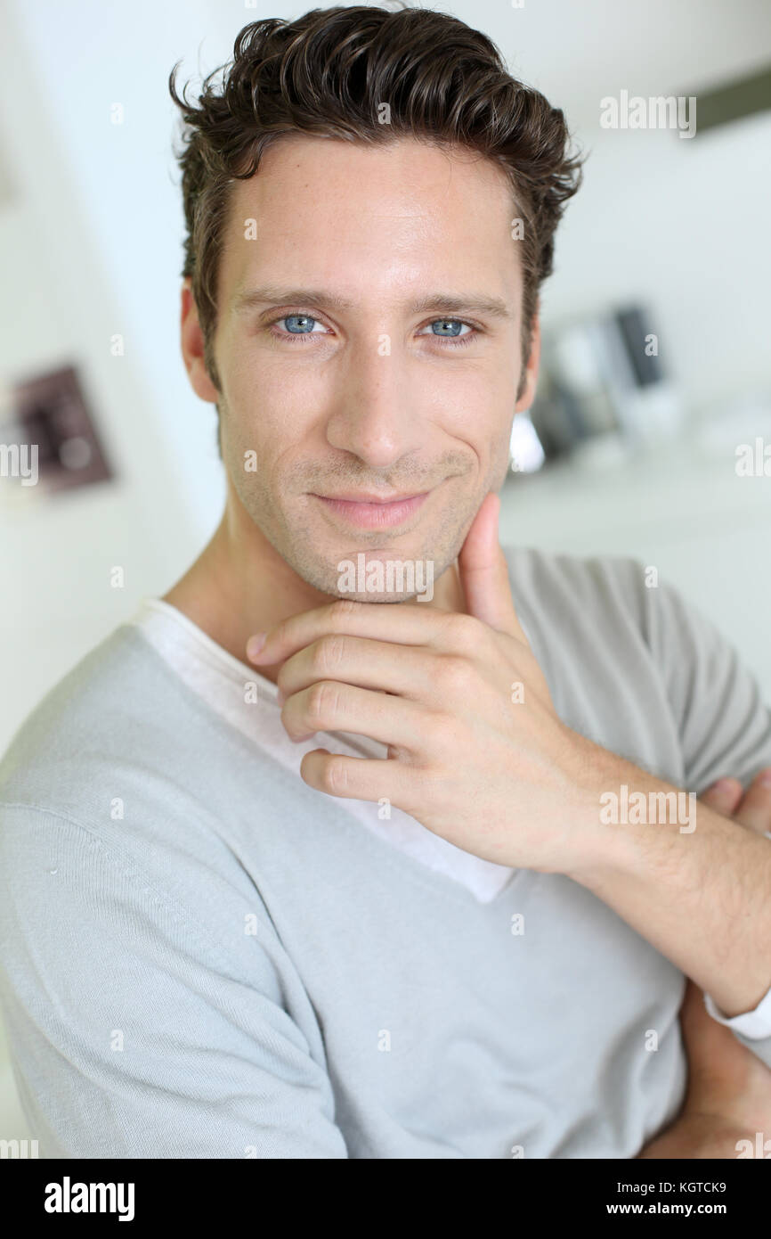 Smiling handsome guy with hand on chin Stock Photo - Alamy