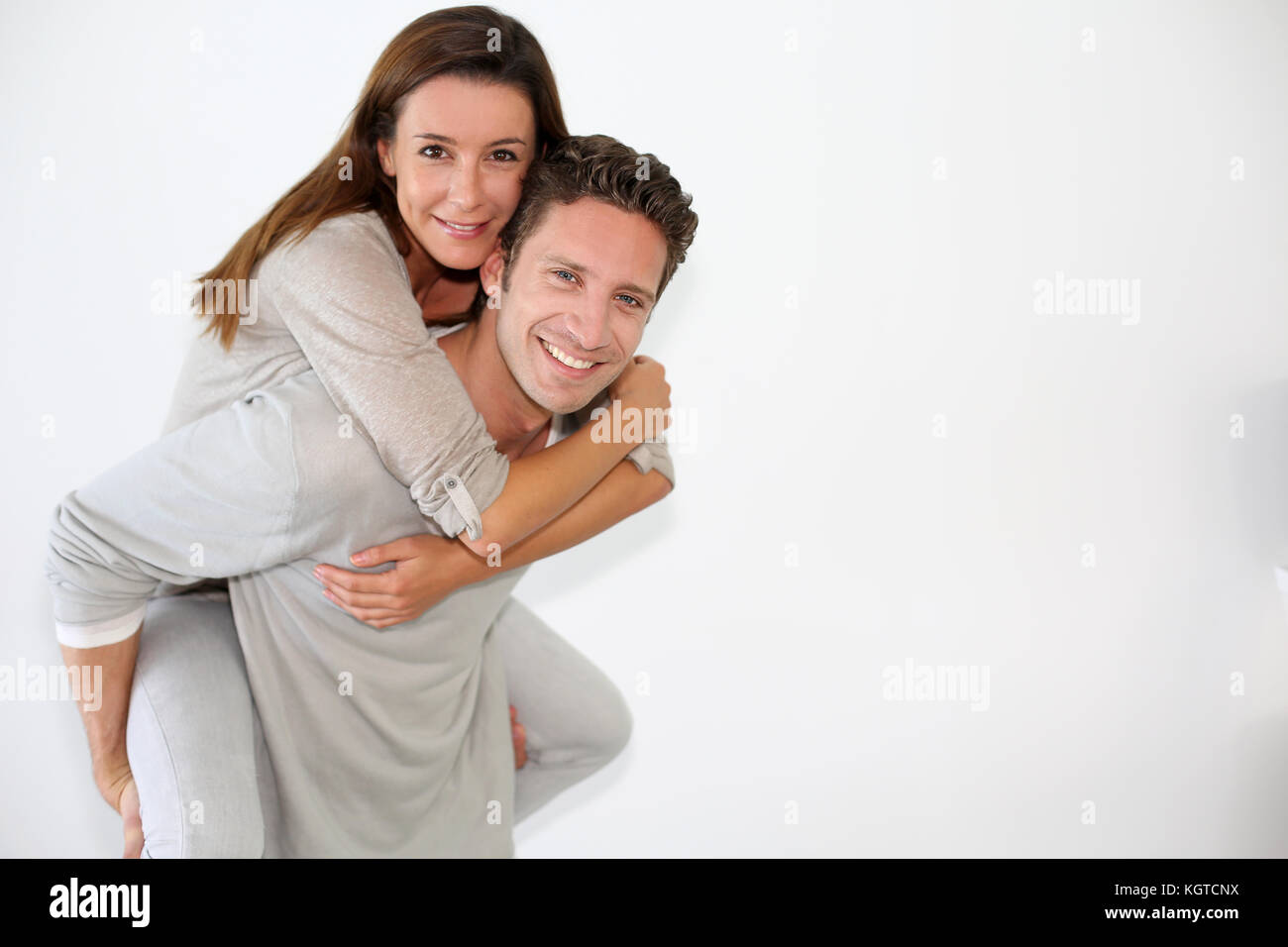 Handsome guy giving piggyback ride to girlfriend Stock Photo - Alamy