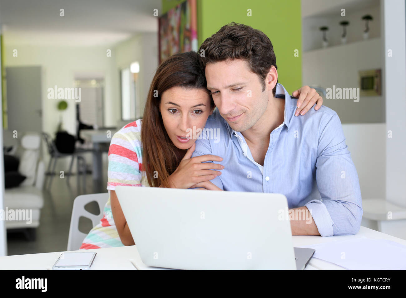 Couple at home sitting in front of laptop Stock Photo - Alamy