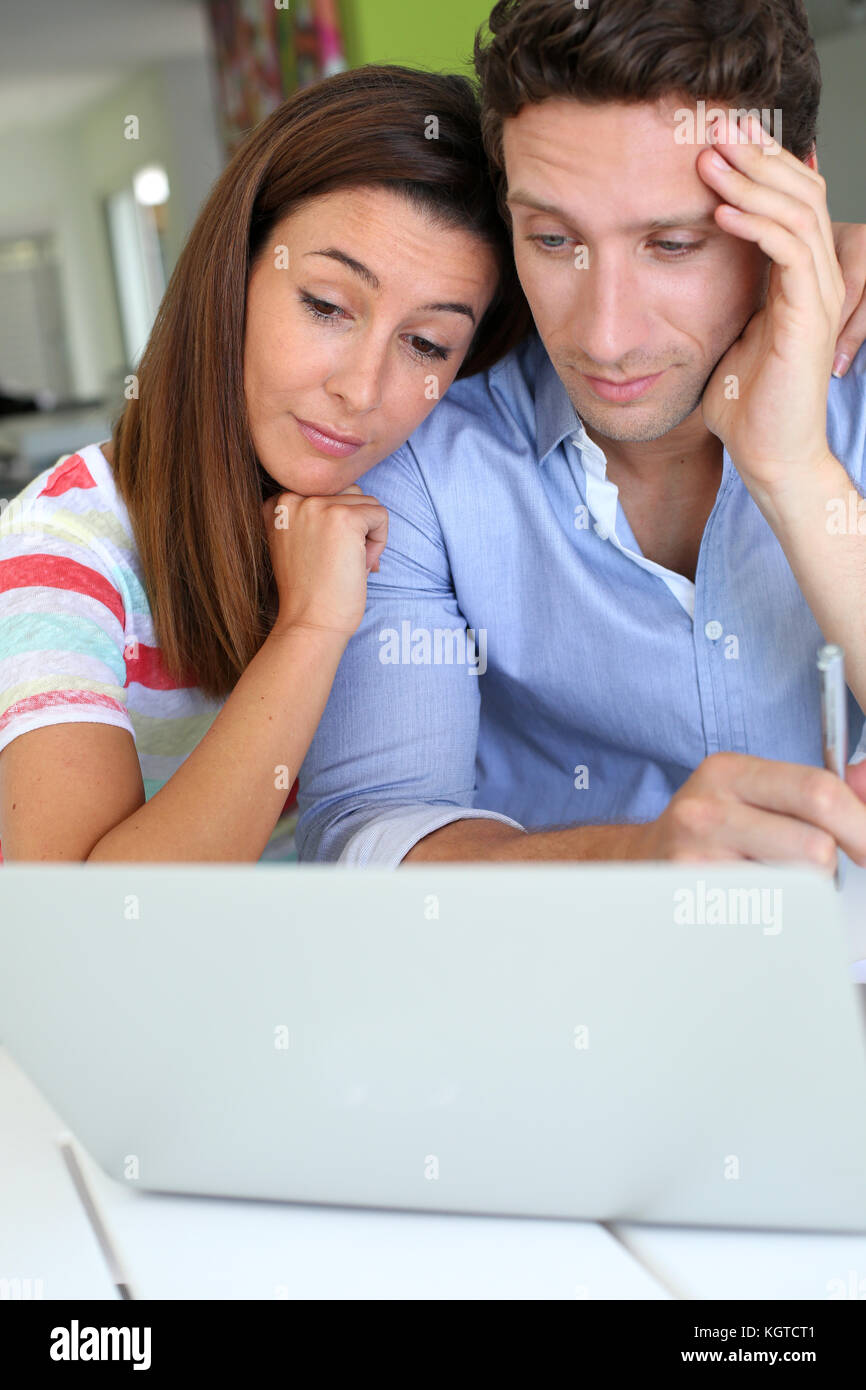Couple looking at bank account on laptop Stock Photo - Alamy