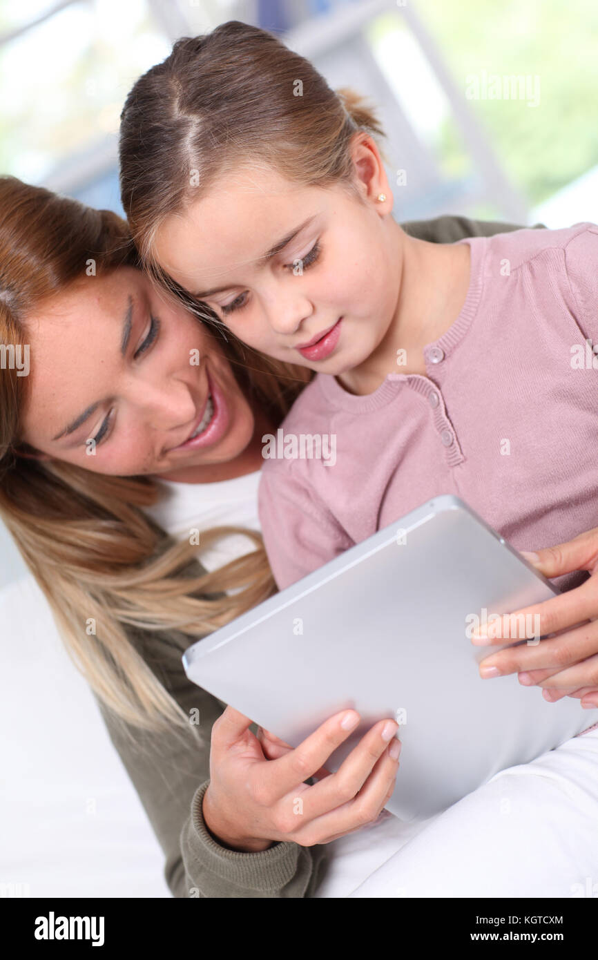 Mother and child using electronic tablet at home Stock Photo - Alamy