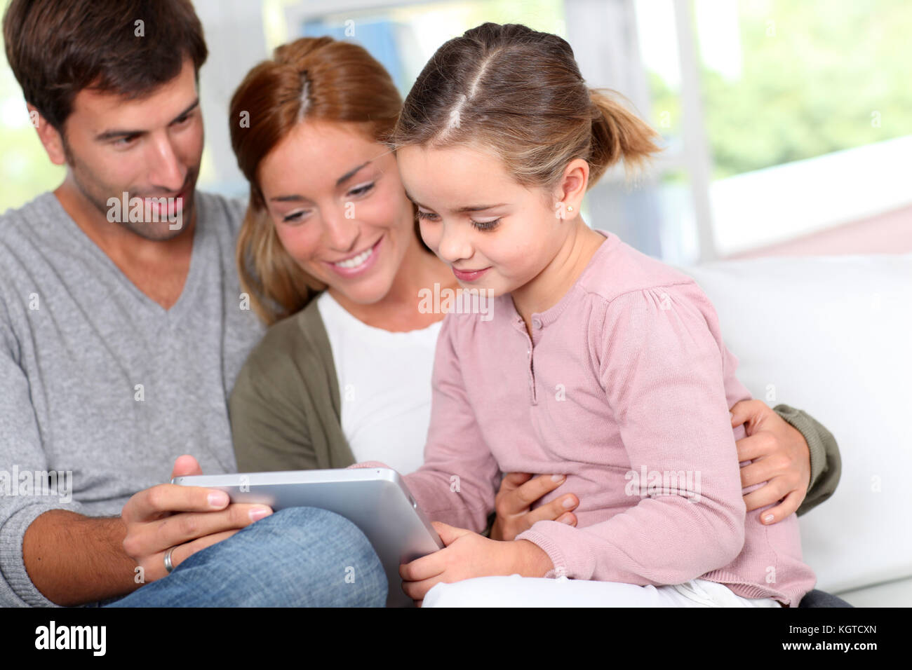 Family using electronic tablet at home Stock Photo - Alamy